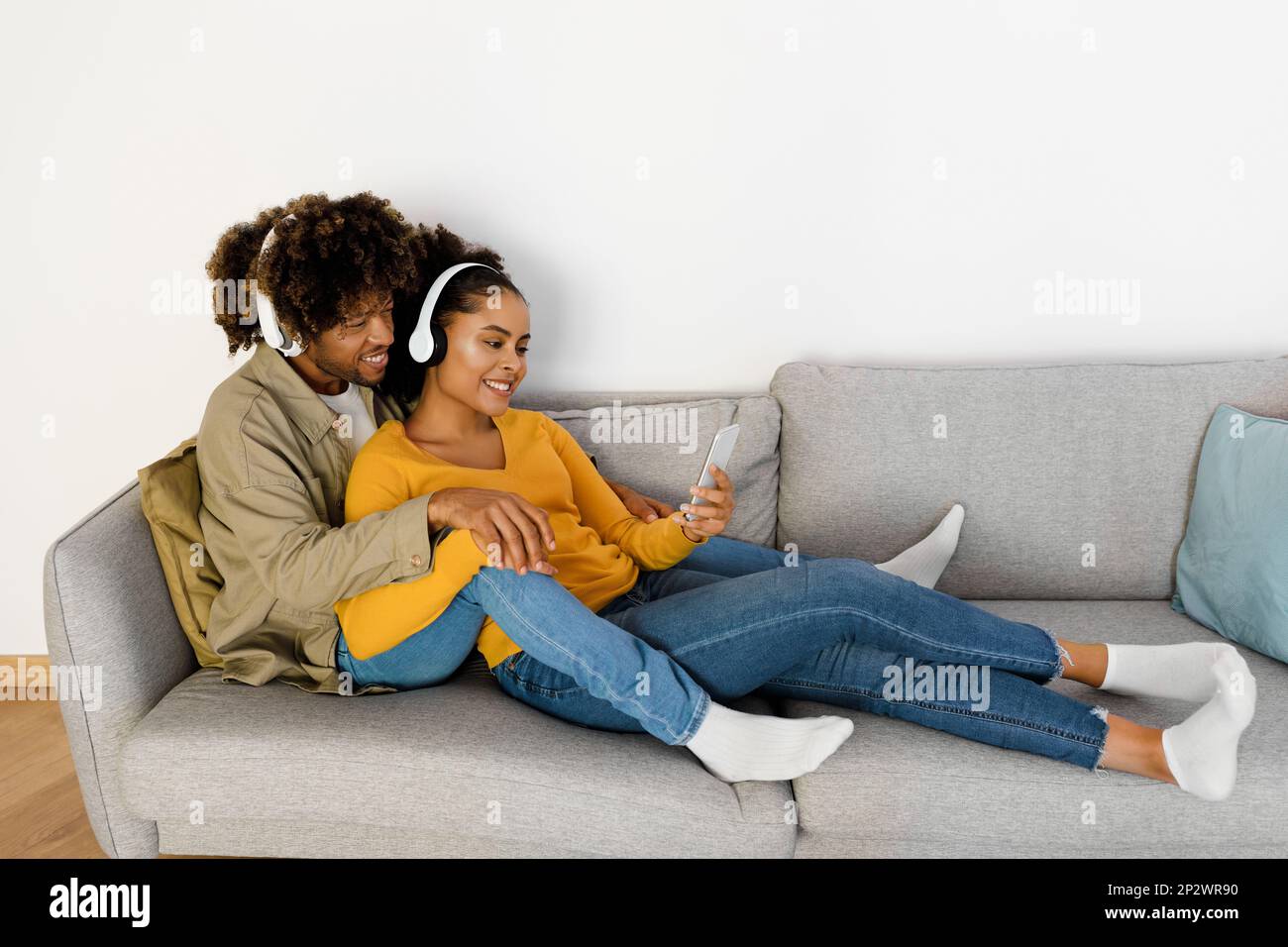 African Couple Hugging Listening Music On Phone Wearing Earphones ...