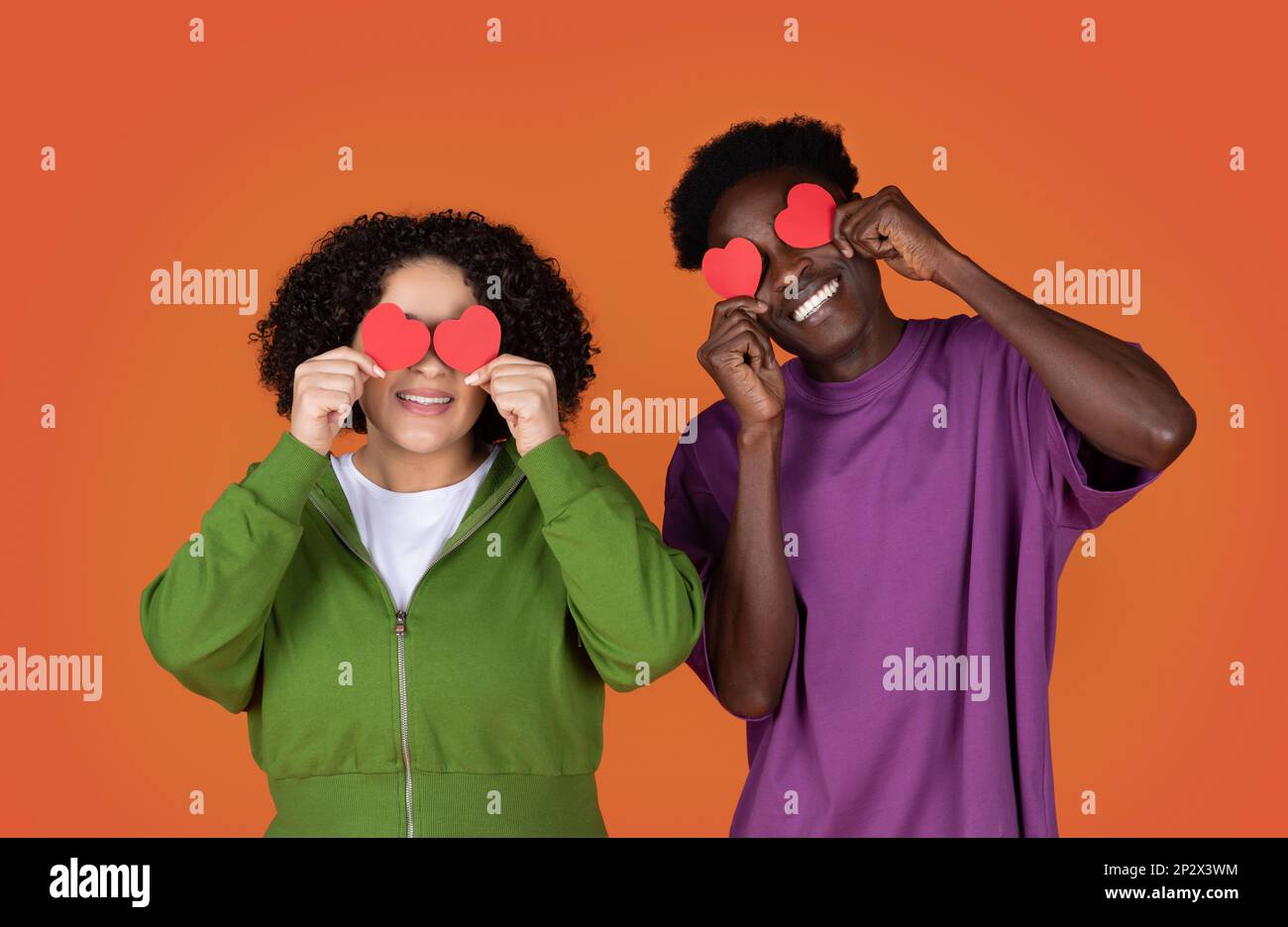 Cute multicultural lovers covering eyes with heart shaped cards Stock ...