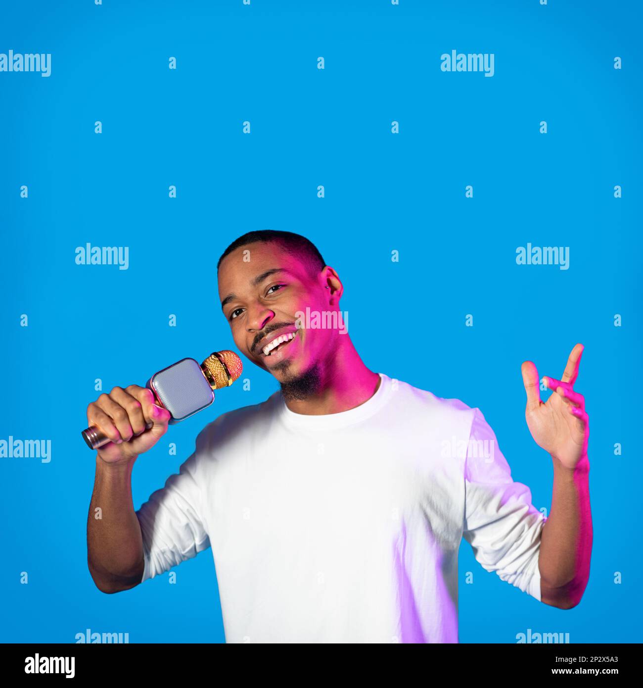 Handsome black male singer looking at camera, holding microphone Stock ...