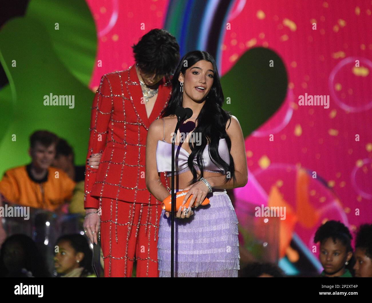 Landon Barker, left, presents the award for favorite female creator to Charli D'Amelio at the ...