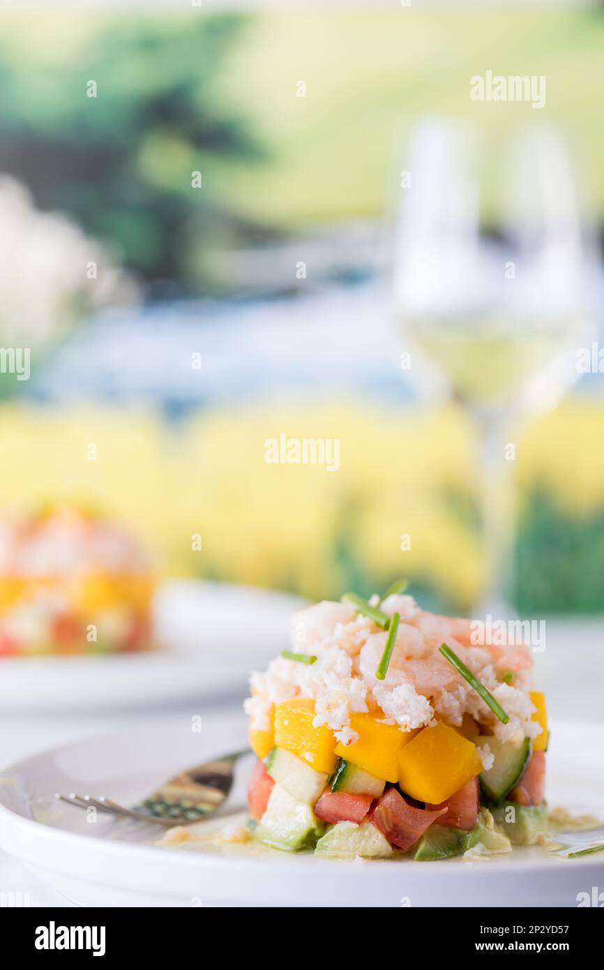 Fresh crab and shrimp stack salad garnished with chives and served with ...
