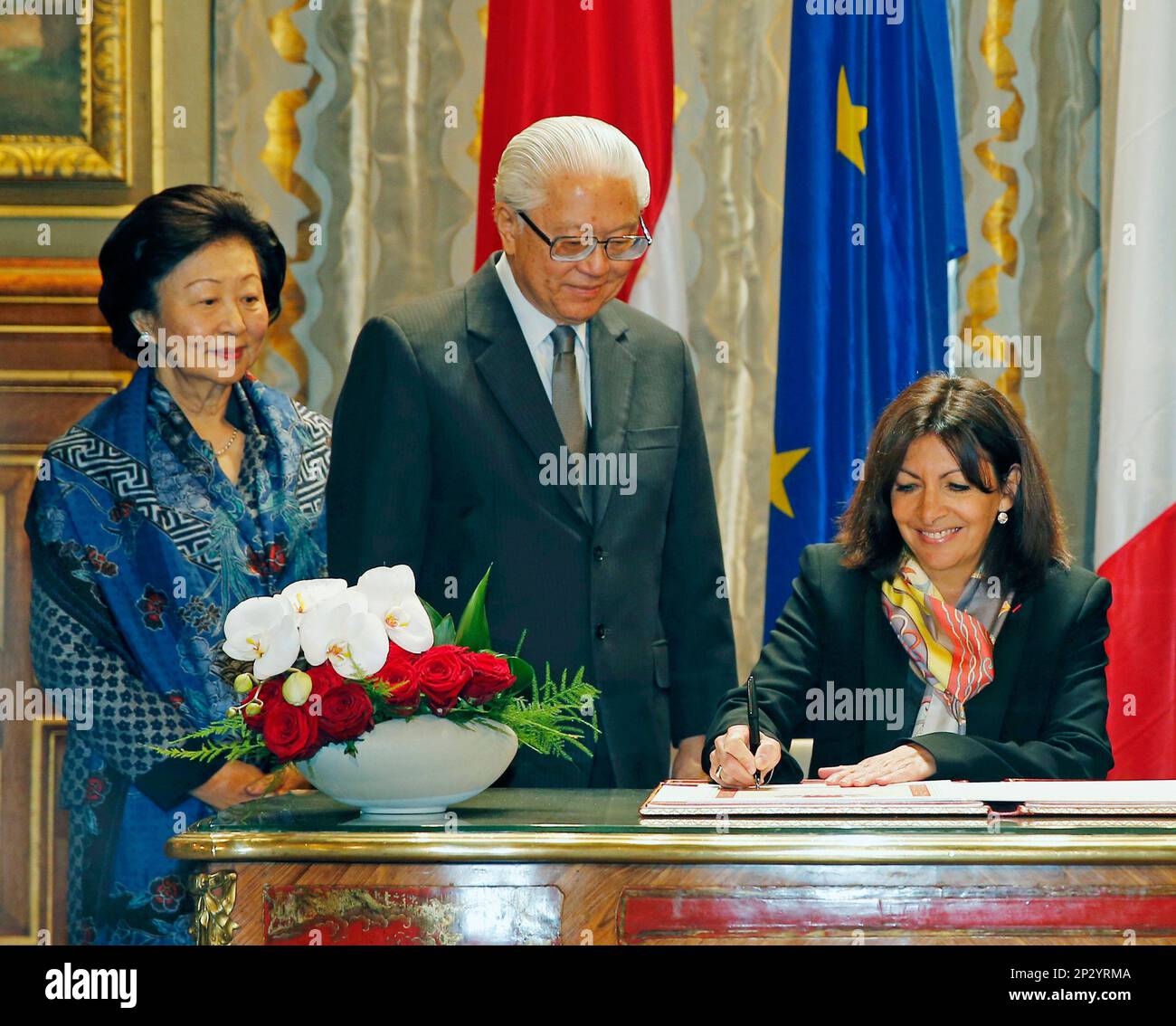 Paris Mayor Anne Hidalgo signs a document while Singapore President ...