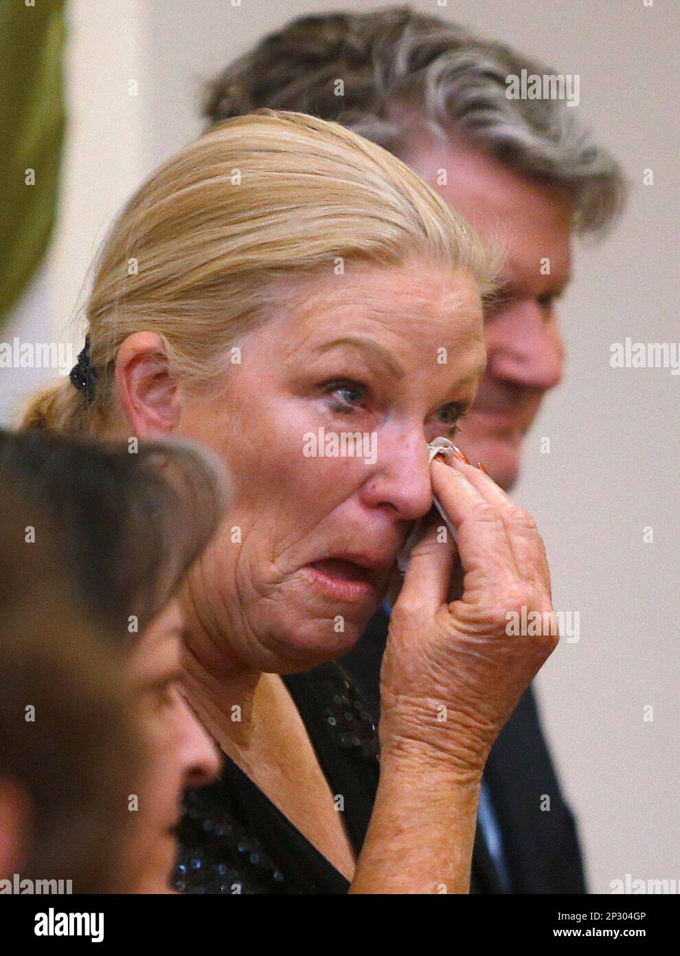 Beth Castro, daughter of former Arizona Gov. Raul Hector Castro, wipes ...