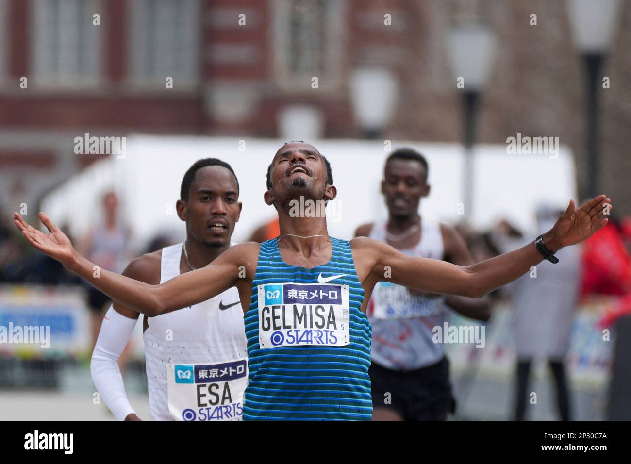 Deso Gelmisa of Ethiopia, center, crosses the finish line, winning the ...