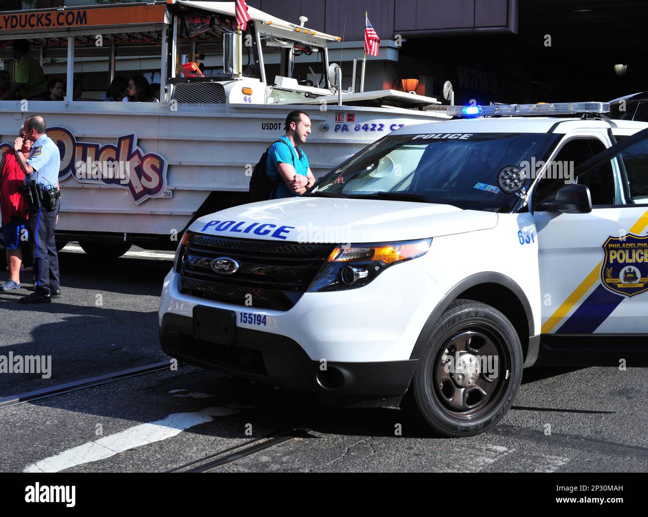 A Philadelphia police officer, left, interviews the husband of a victim ...