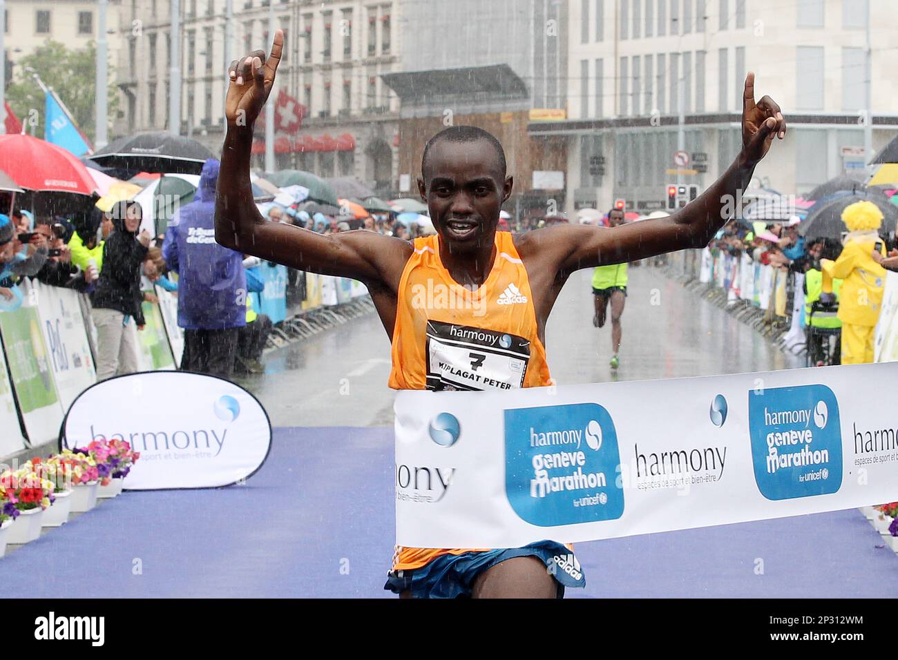 Kenyan Kiplagat Peter raises his arm as he crosses the finish line to ...