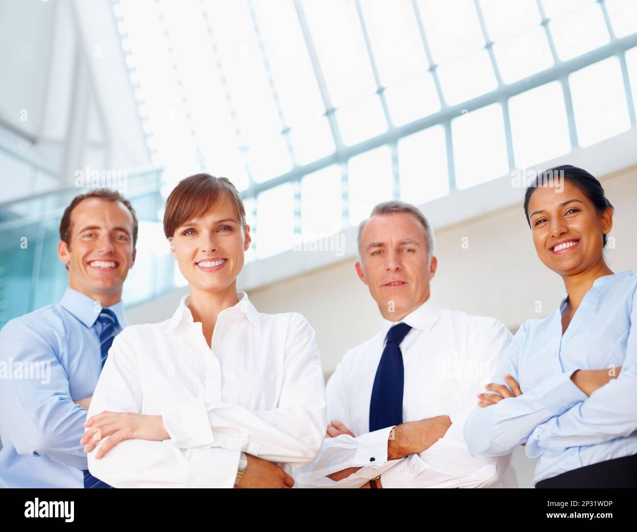 Success with teamwork. Confident happy team standing with arms folded ...