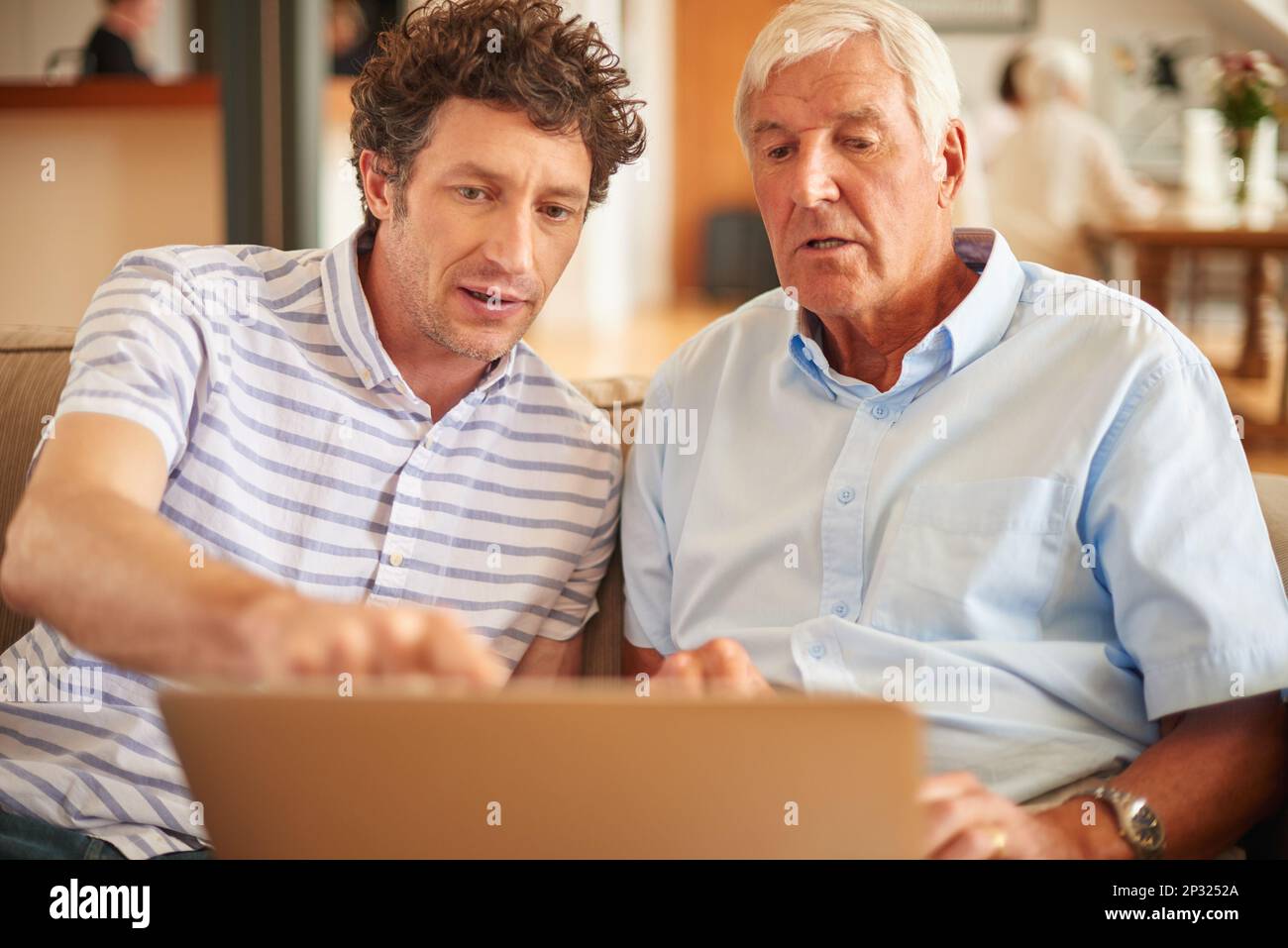 Teaching his dad some web basics. a man showing his father something on ...