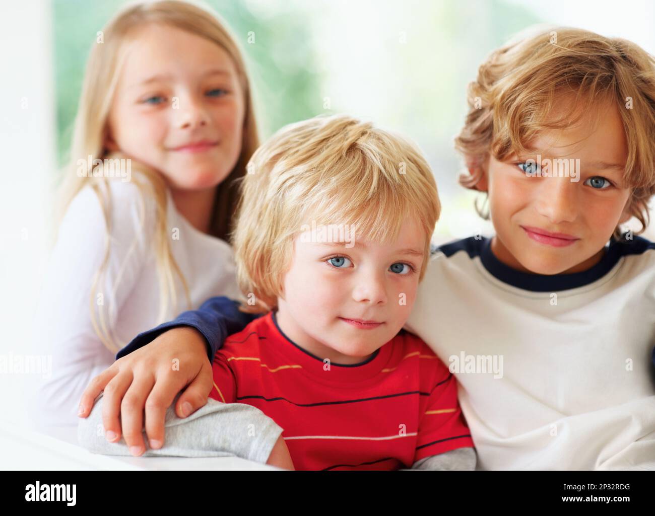 Two cute brothers and a sister sitting together. Portrait of two cute ...