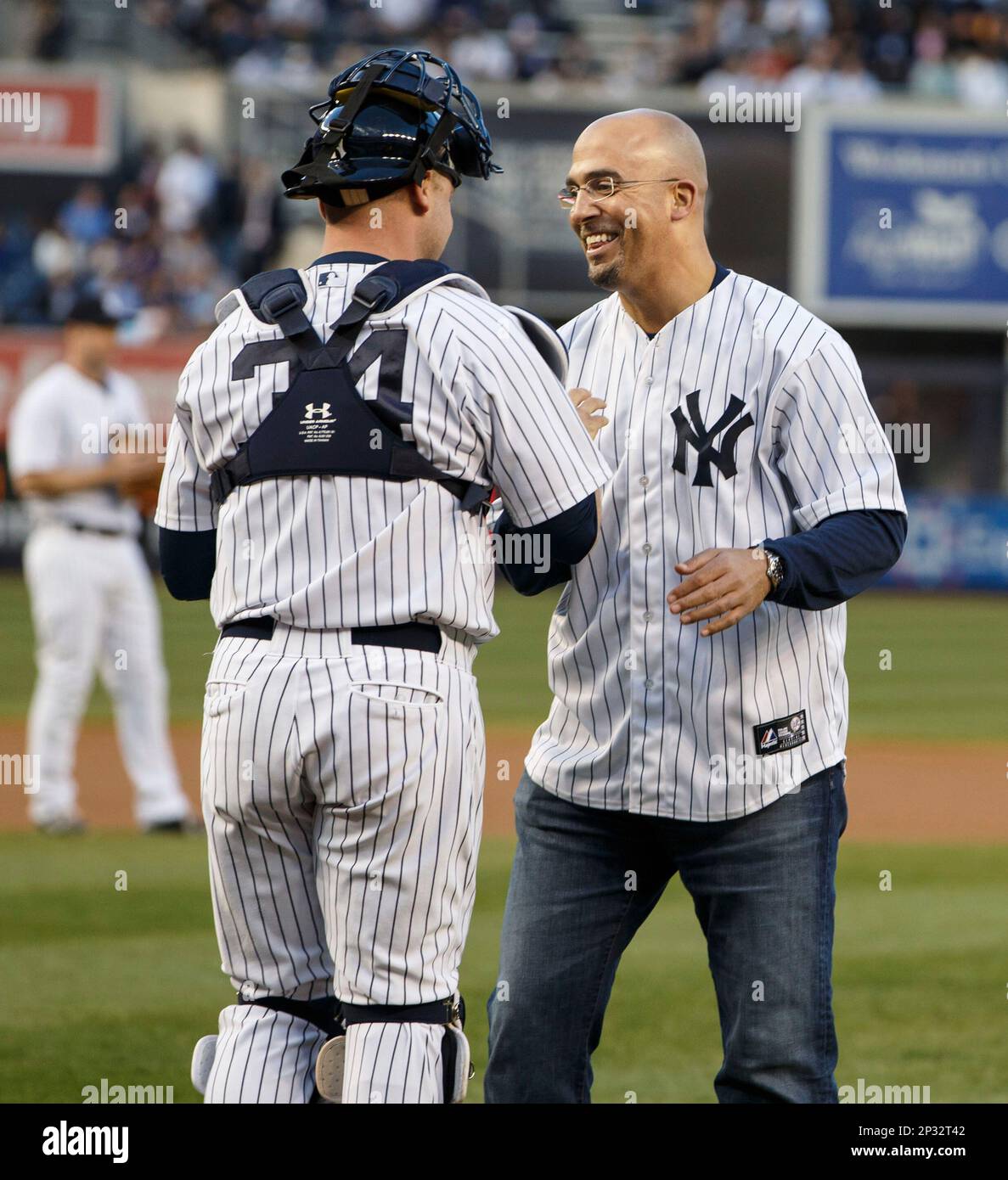 Penn State head coach James Franklin is greeted by Yankee catcher Brian McCann after throwing ...