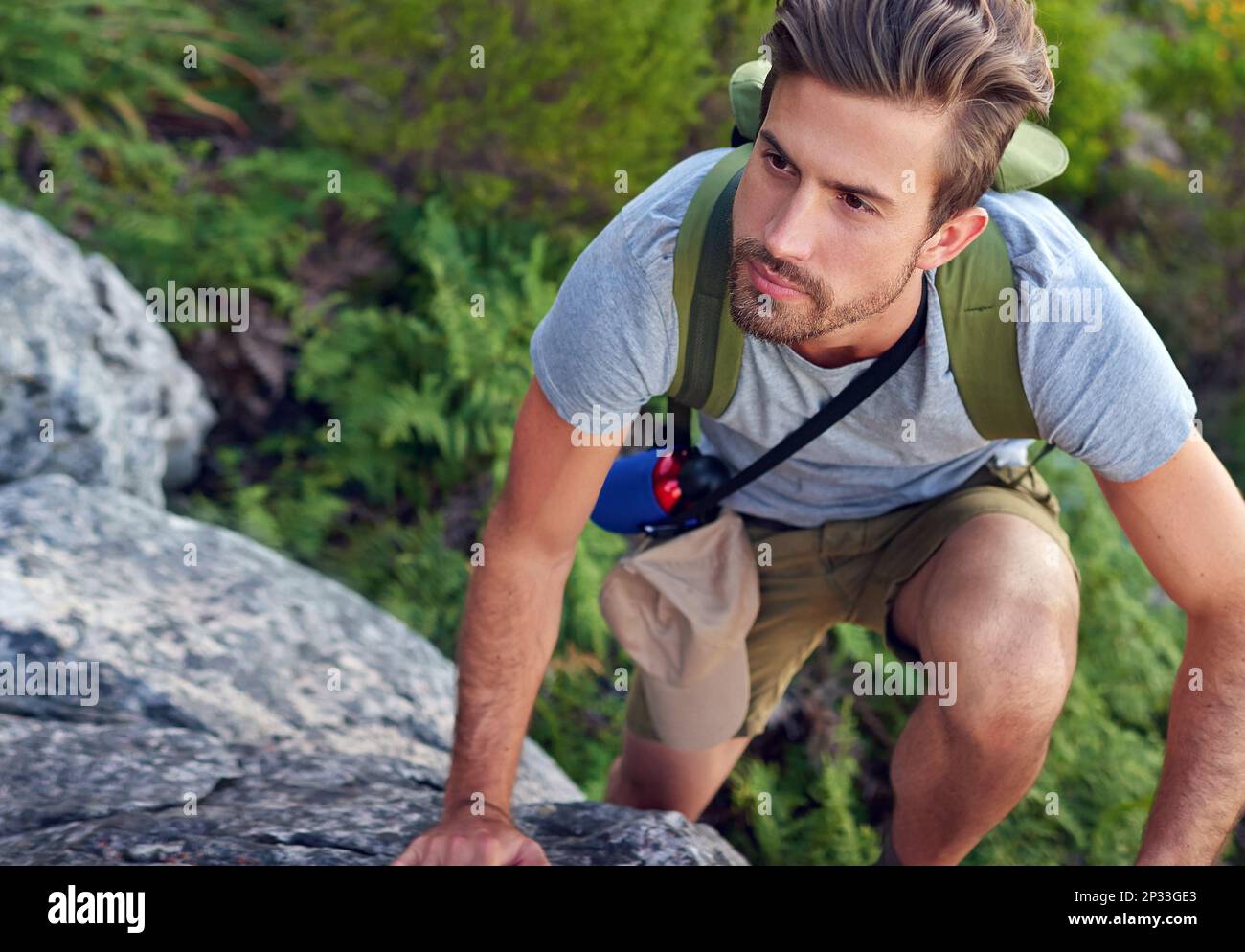 Making his way to the top. a handsome young man scaling a mountain ...