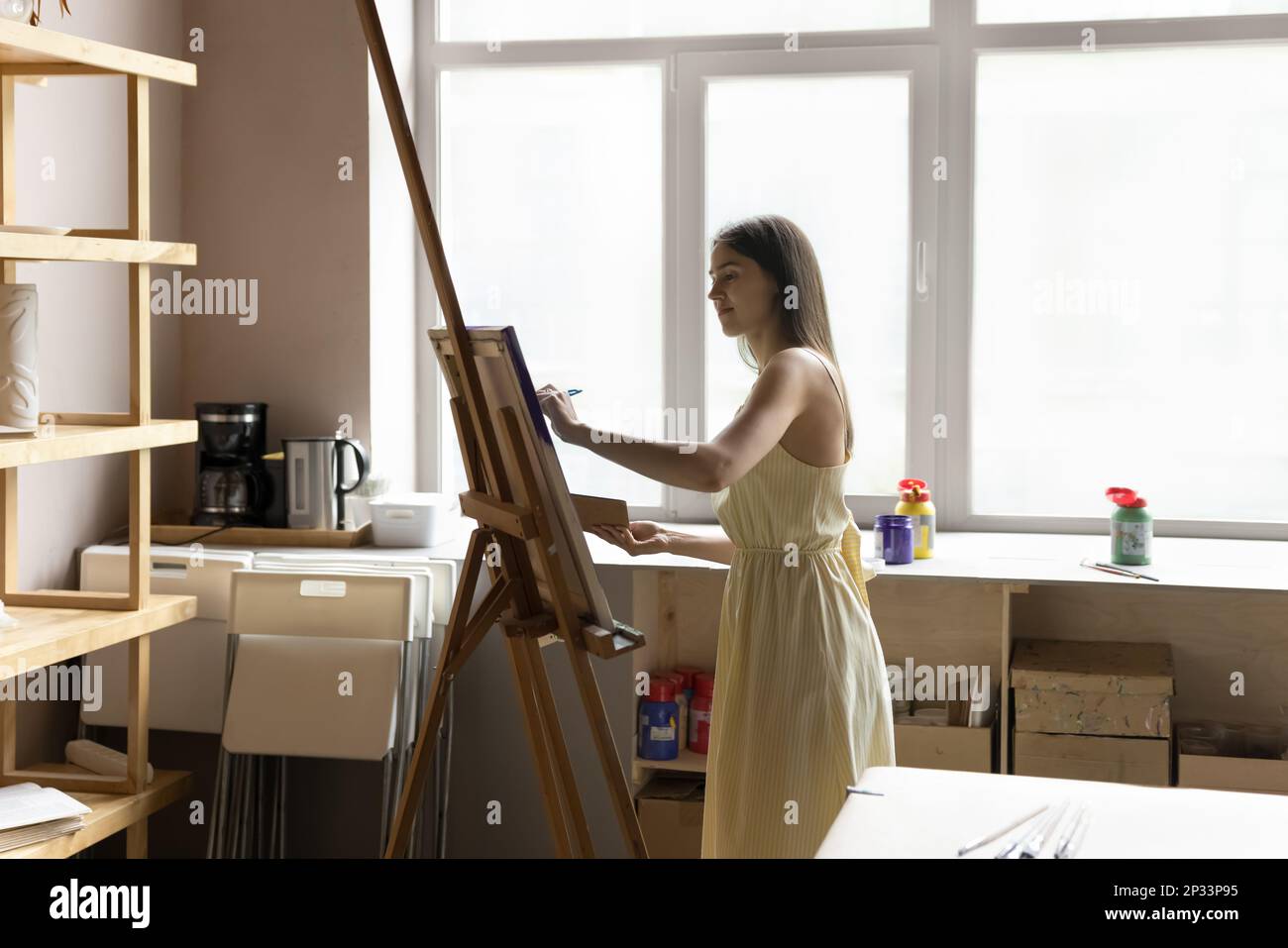 Positive inspired young artist woman working in art school studio Stock ...