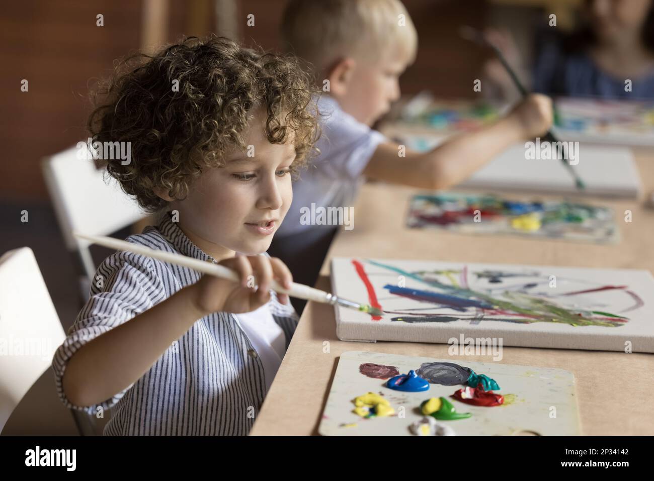 Pretty pupil kid boy painting on class, studying art Stock Photo - Alamy