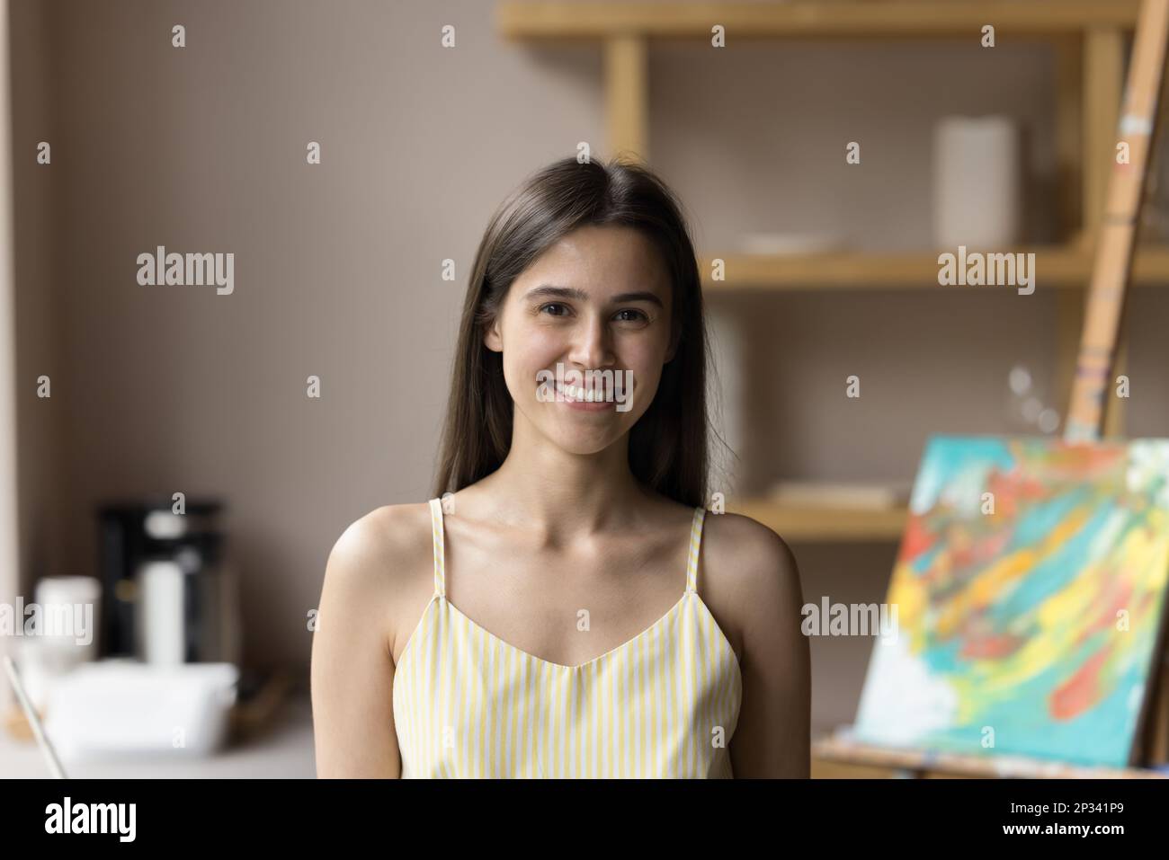 Cheerful pretty young art school student posing in creative space Stock ...