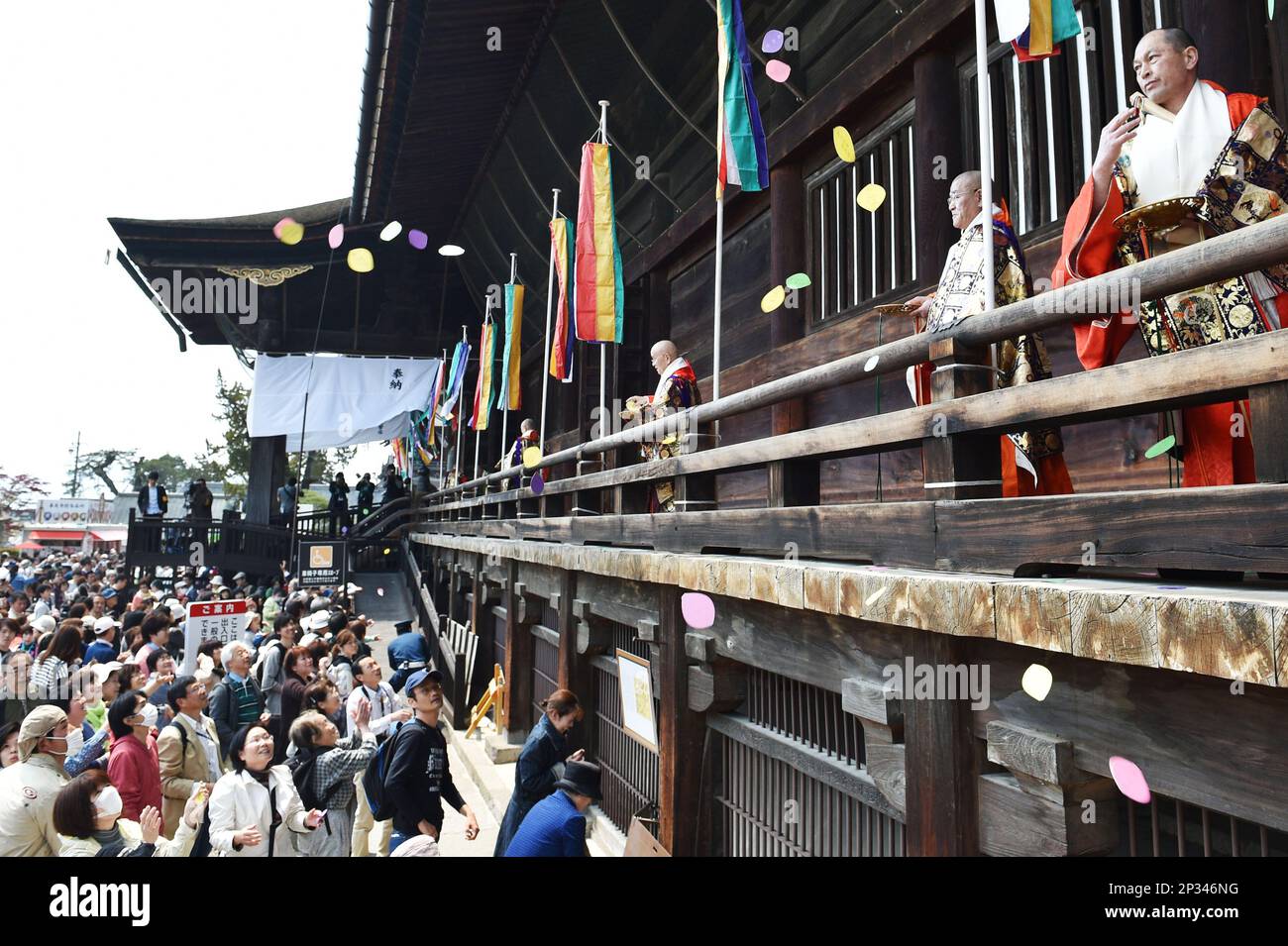 Priests perform a sange, which means to mourn by throwing flowers at ...