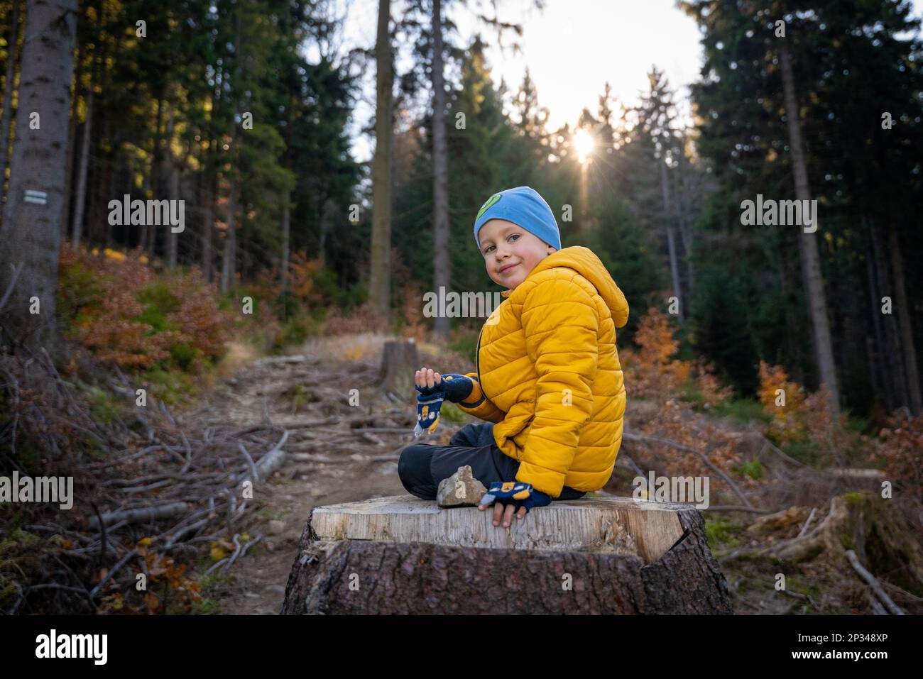 Child sitting on a tree stump hi-res stock photography and images - Alamy