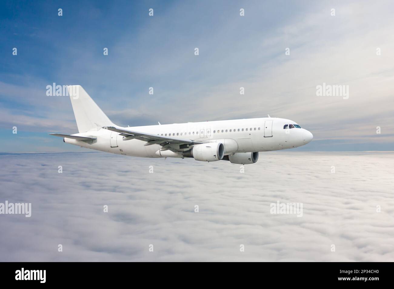 White passenger jetliner fly in the air above the clouds Stock Photo ...