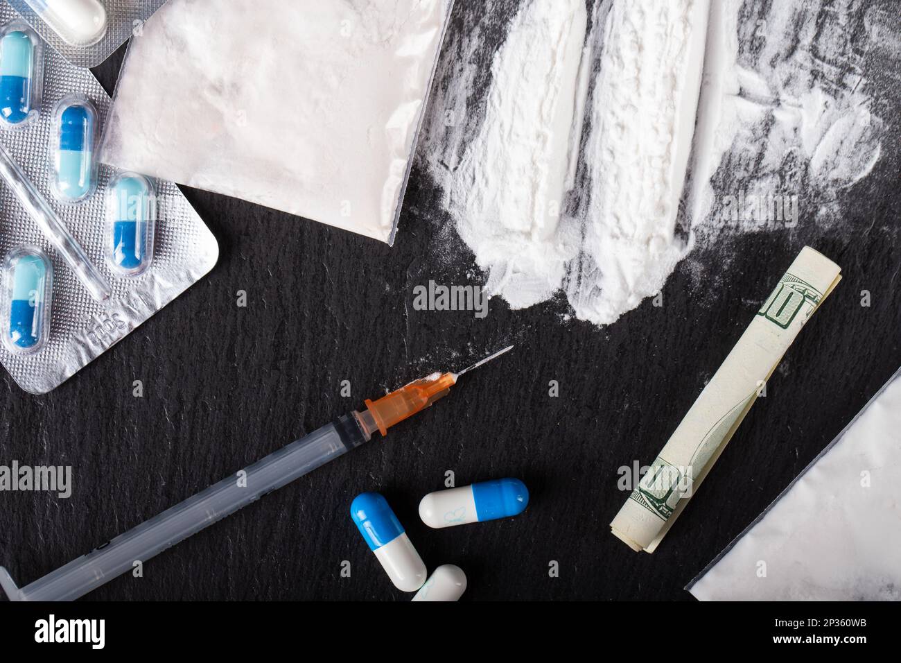Drug Dealer's Table. Drugs are scattered on the black table, there is a ...