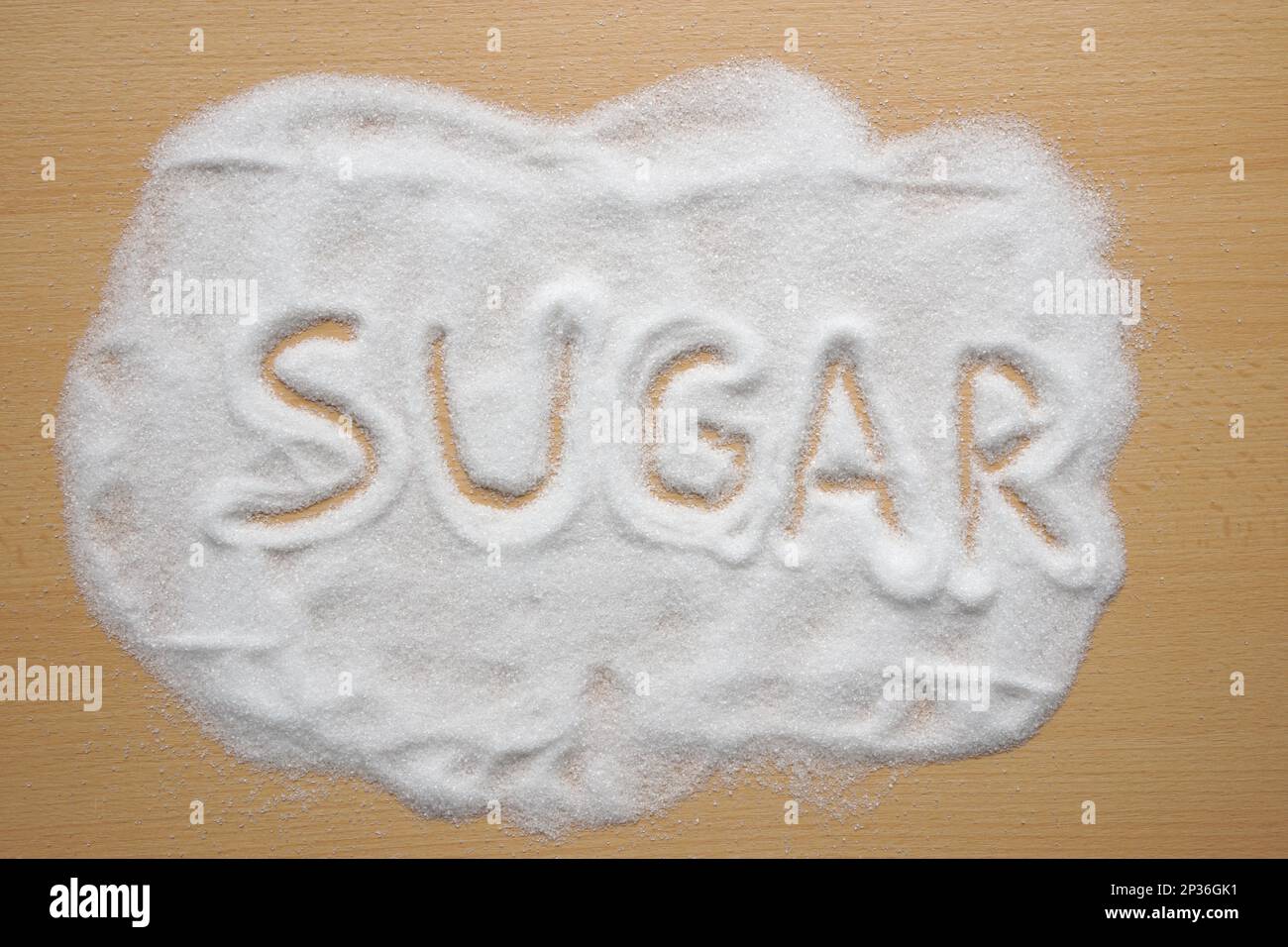 word sugar written in sugar spread out on kitchen table Stock Photo - Alamy