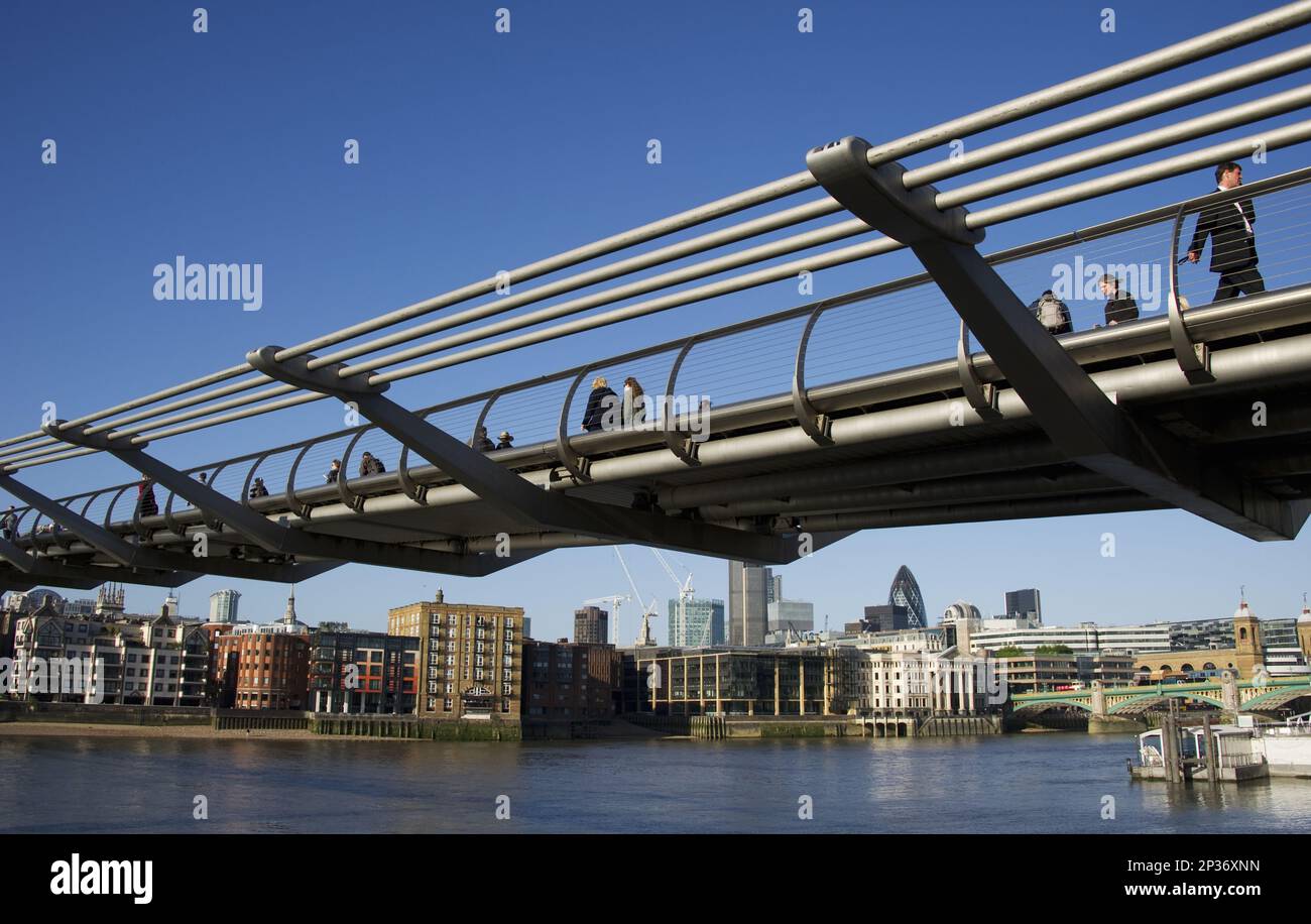 Pedestrians crossing river on steel suspension bridge, Millennium ...