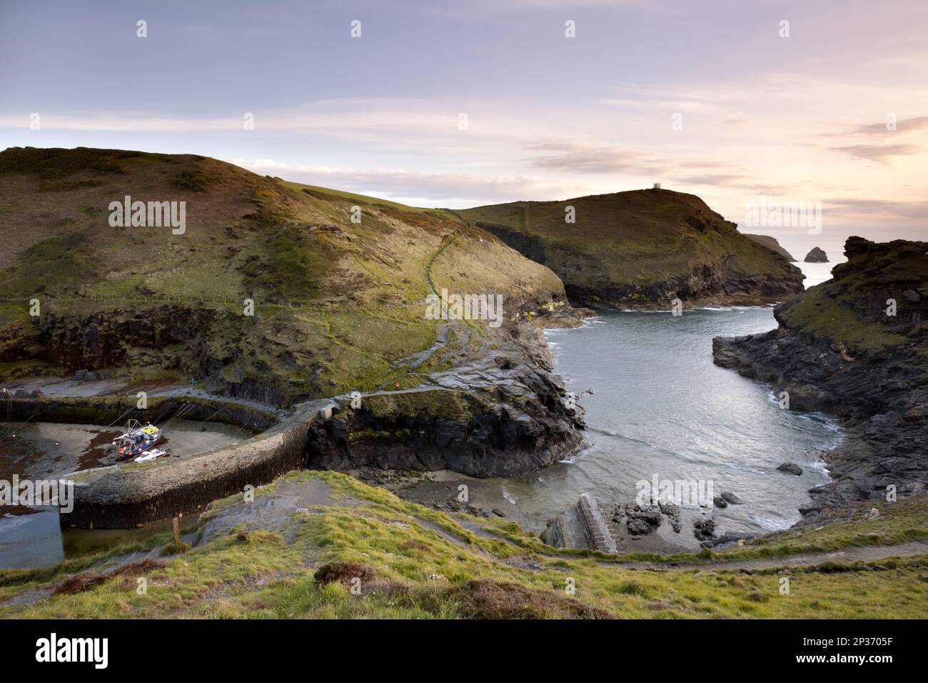 View over the harbour walls of a fishing village in a natural bay at ...