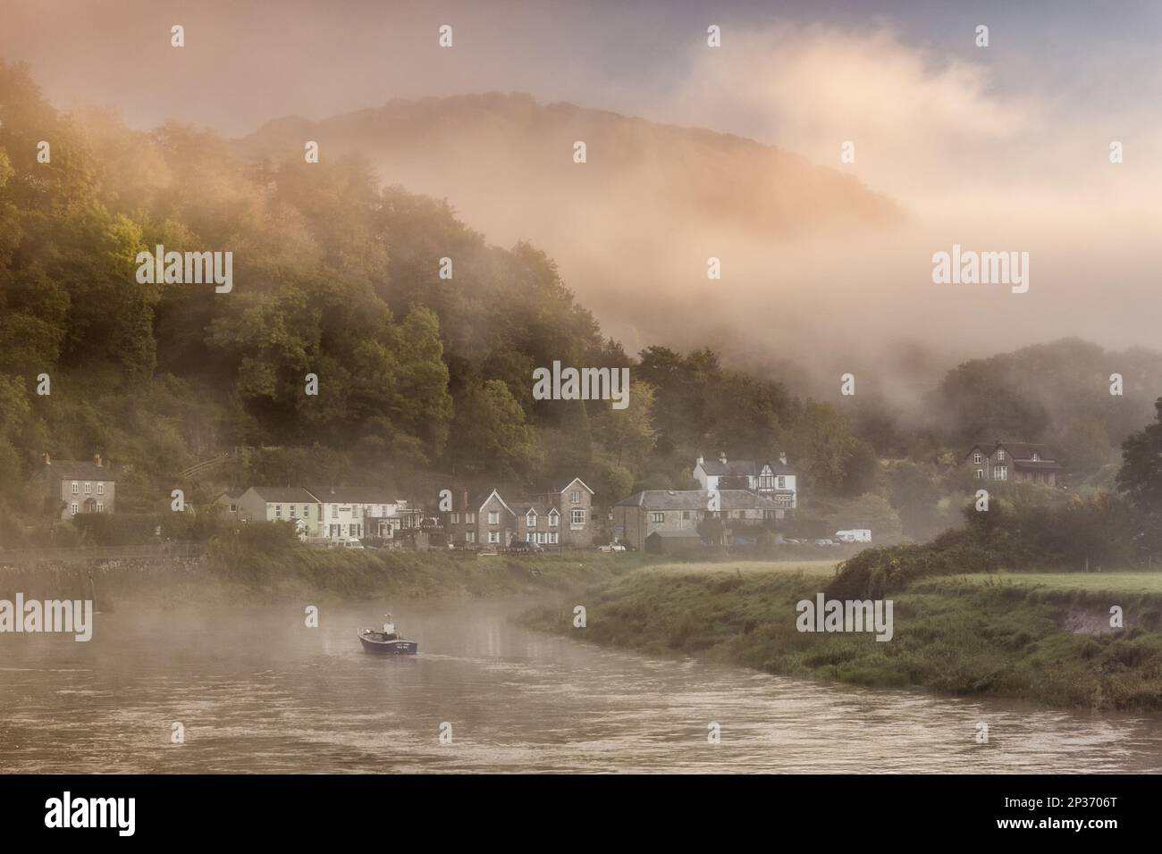 View of a riverside village in the mist at dawn, Tintern, River Wye ...