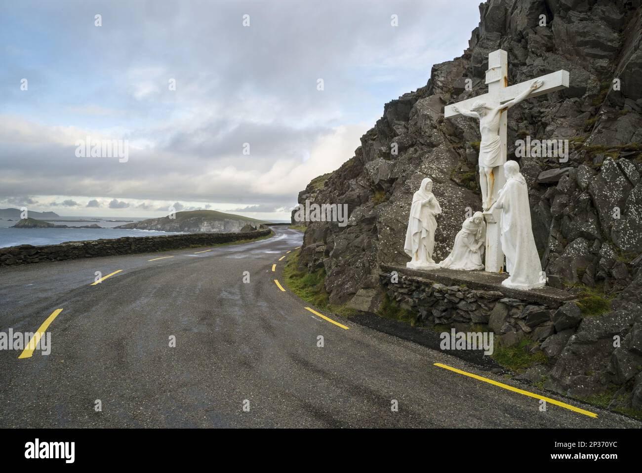 Statue with Jesus on Crucifix with Mary and Saint John, beside coastal ...