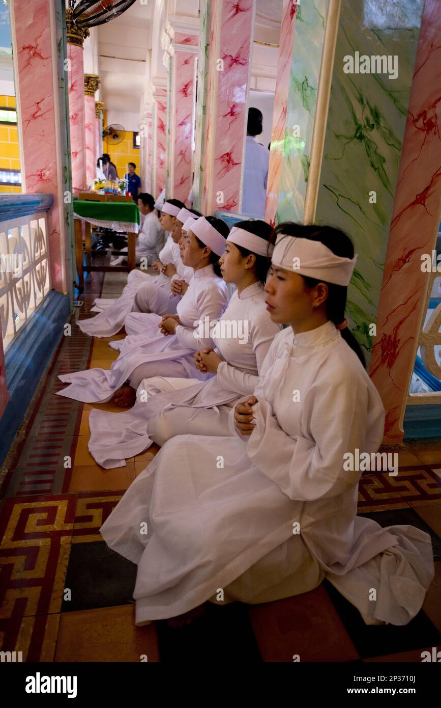 Caodaist disciples sitting on balcony during ceremony, Cao Dai temple ...