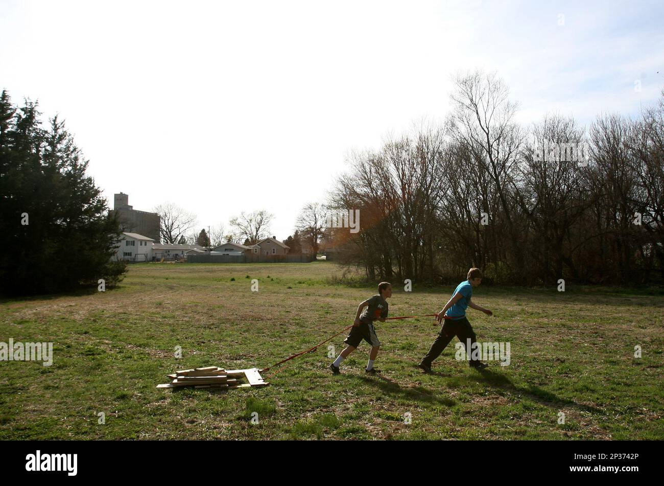 Cousins Jordan Peak, left, and Evan Adler haul scraps of wood to a ...