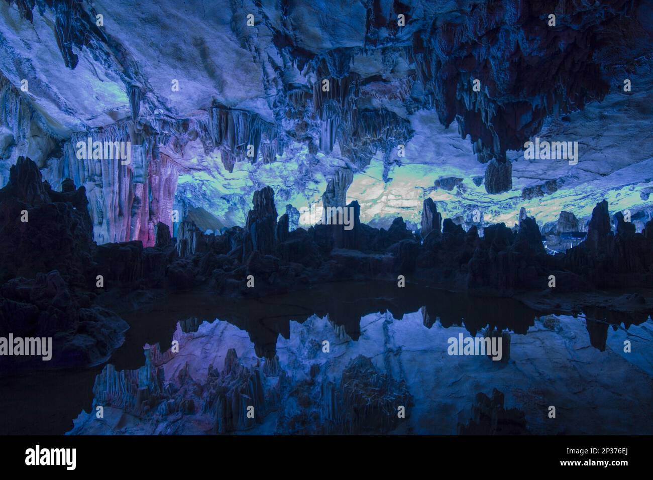 Interior of a limestone cave with stalactites and stalagmites reflected ...