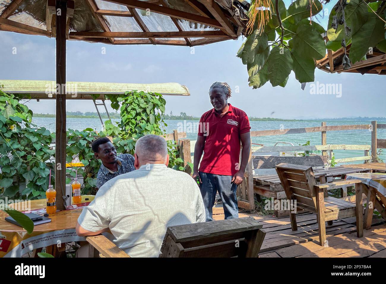 Owner James Kateeba speaks to customers on his floating restaurant and ...