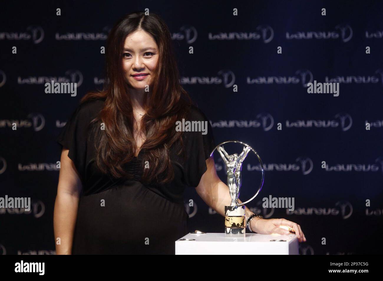 Retired Chinese tennis star Li Na poses with her trophy after the award ...