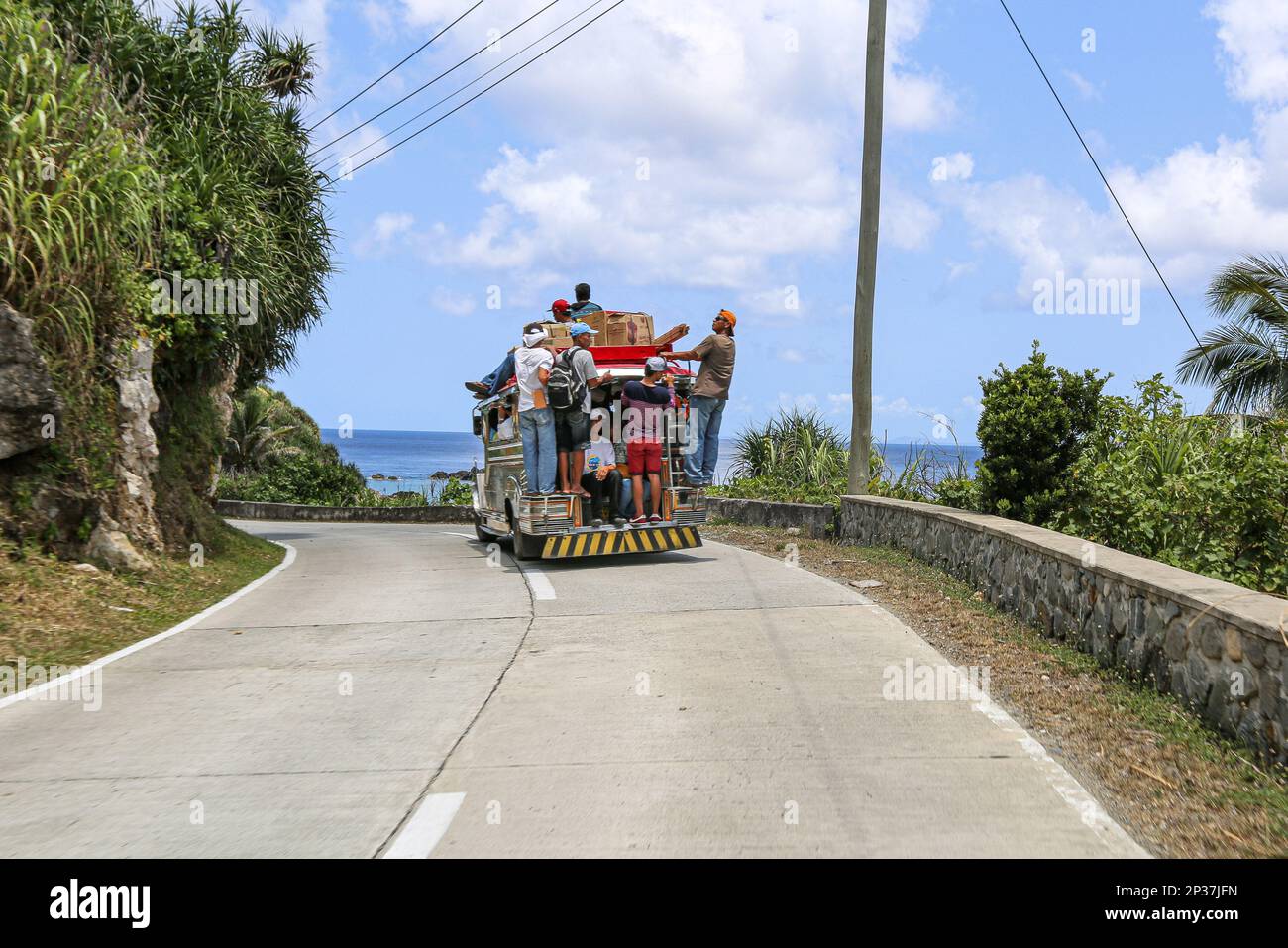 Overloaded jeepney, public transport driving on winding roads of Batan ...