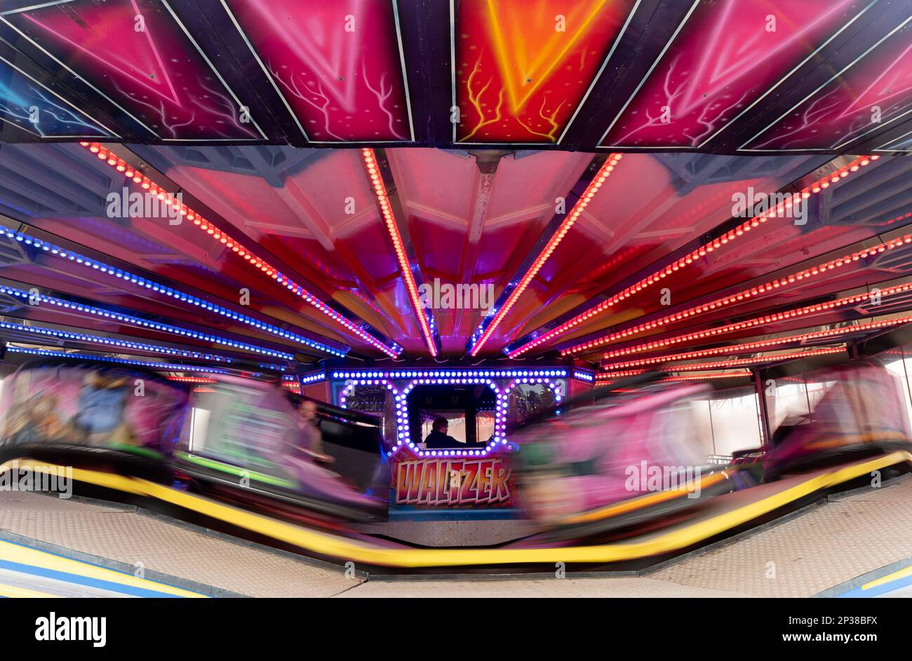 Bright lights of the Waltzer ride of a funfair with a slow shutter ...
