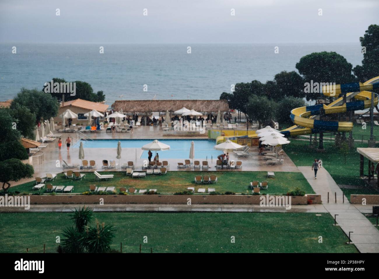 Blurred Shot Of Hotel Area With Pool And Water Slide During Rain ...