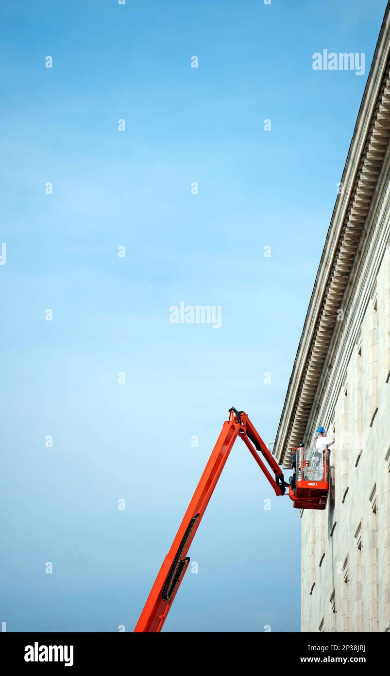 UNITED STATES - OCTOBER 24: A worker scrapes paint from a window frame ...