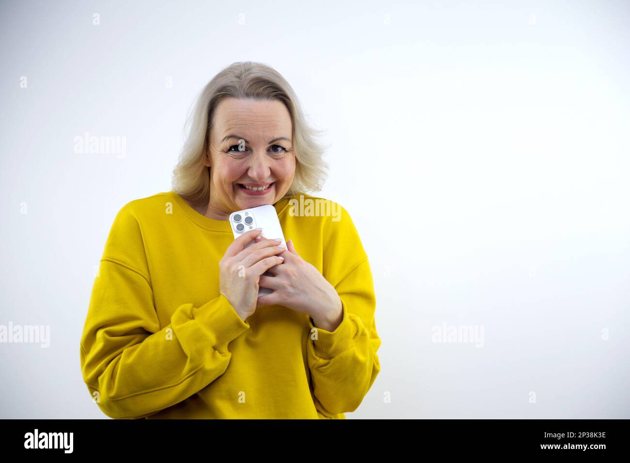 cute woman plotting something holding phone in her hands wants to call ...