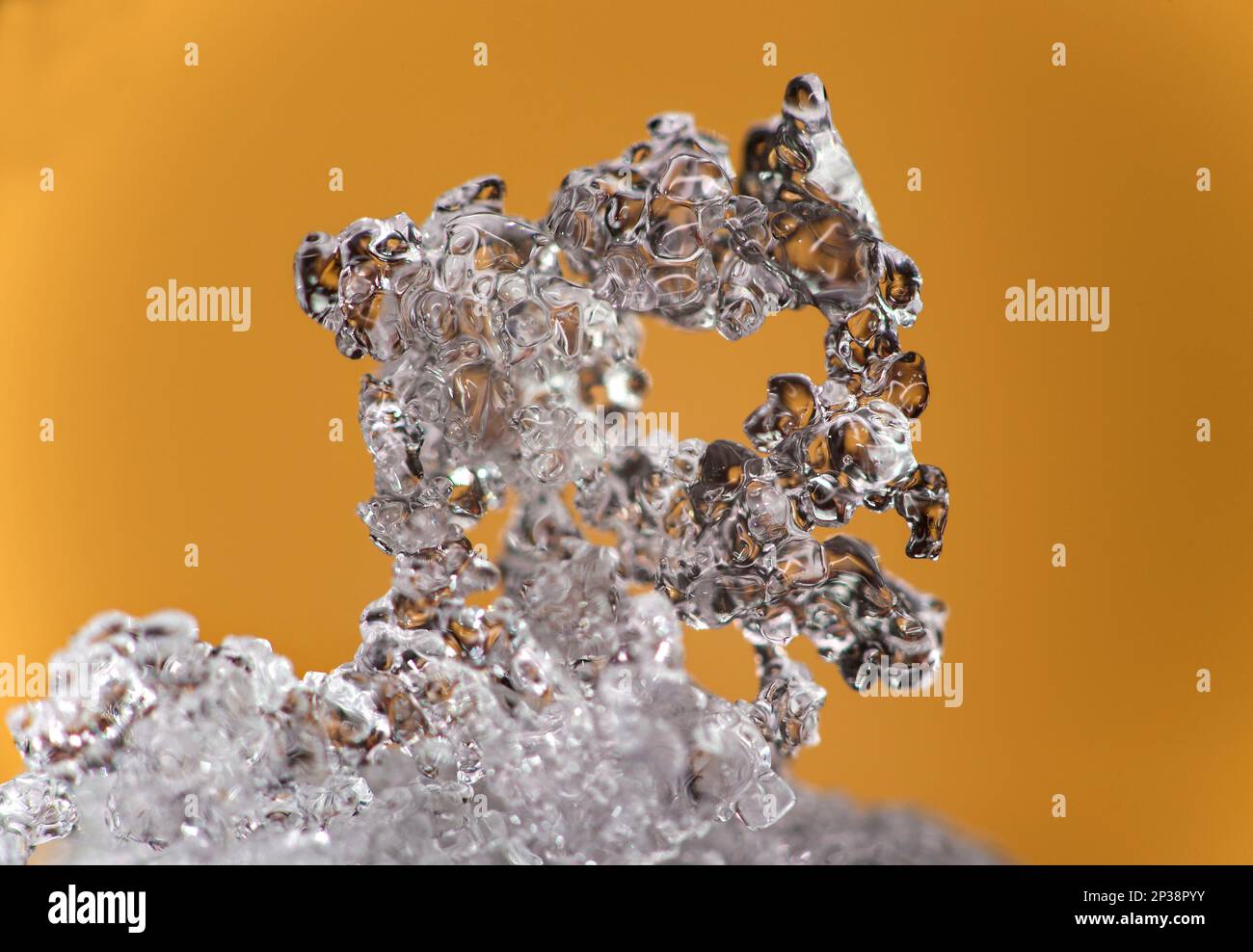 Ephemeral art, ice crystals from frozen snow against a coloured ...