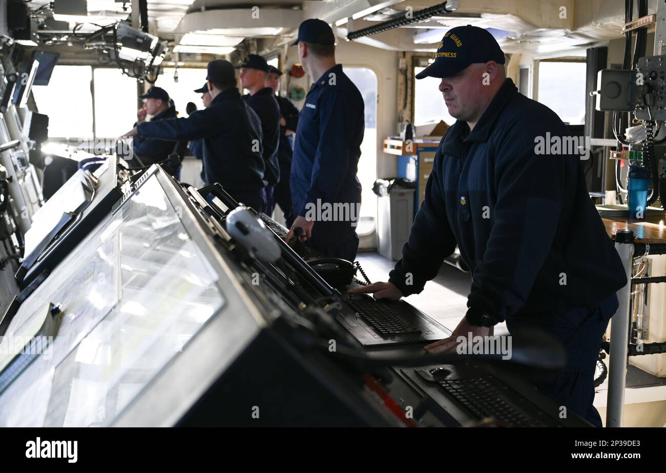 Crewmembers aboard the Coast Guard Cutter Cypress work together to ...