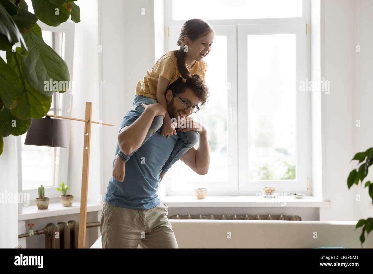 Positive excited young dad piggybacking little daughter kid Stock Photo ...