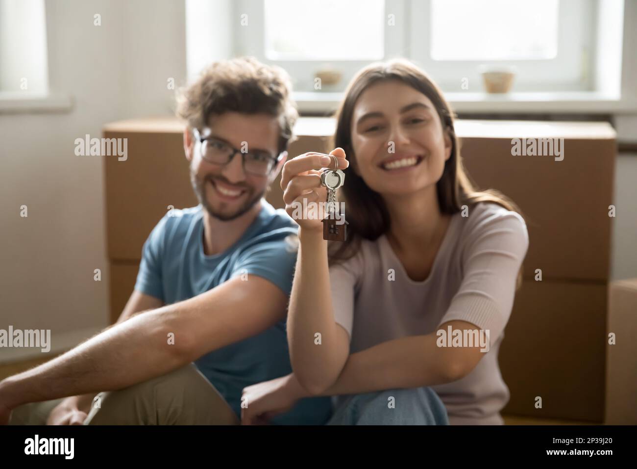 Happy young couple showing keys from hew home together Stock Photo - Alamy