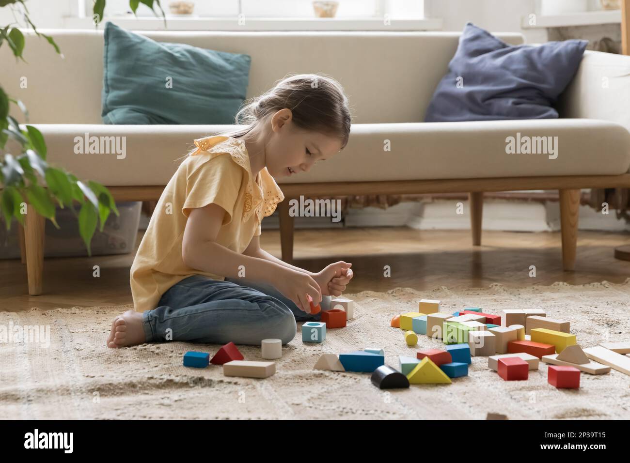 Focused cute little kid girl playing learning game on floor Stock Photo ...