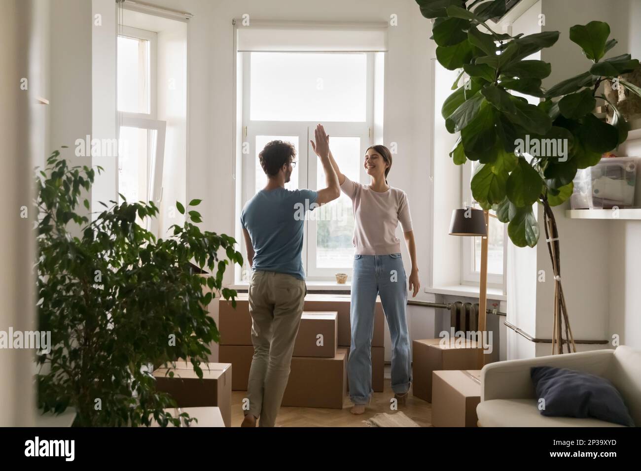 Positive couple clapping hands, giving high five over boxes Stock Photo ...