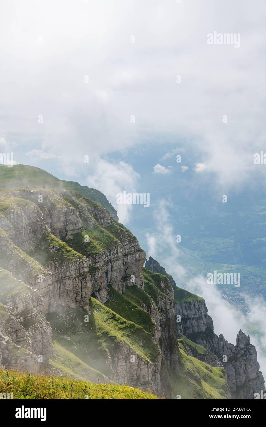 A steep cliff overgrown with grass and hidden by clouds Stock Photo - Alamy