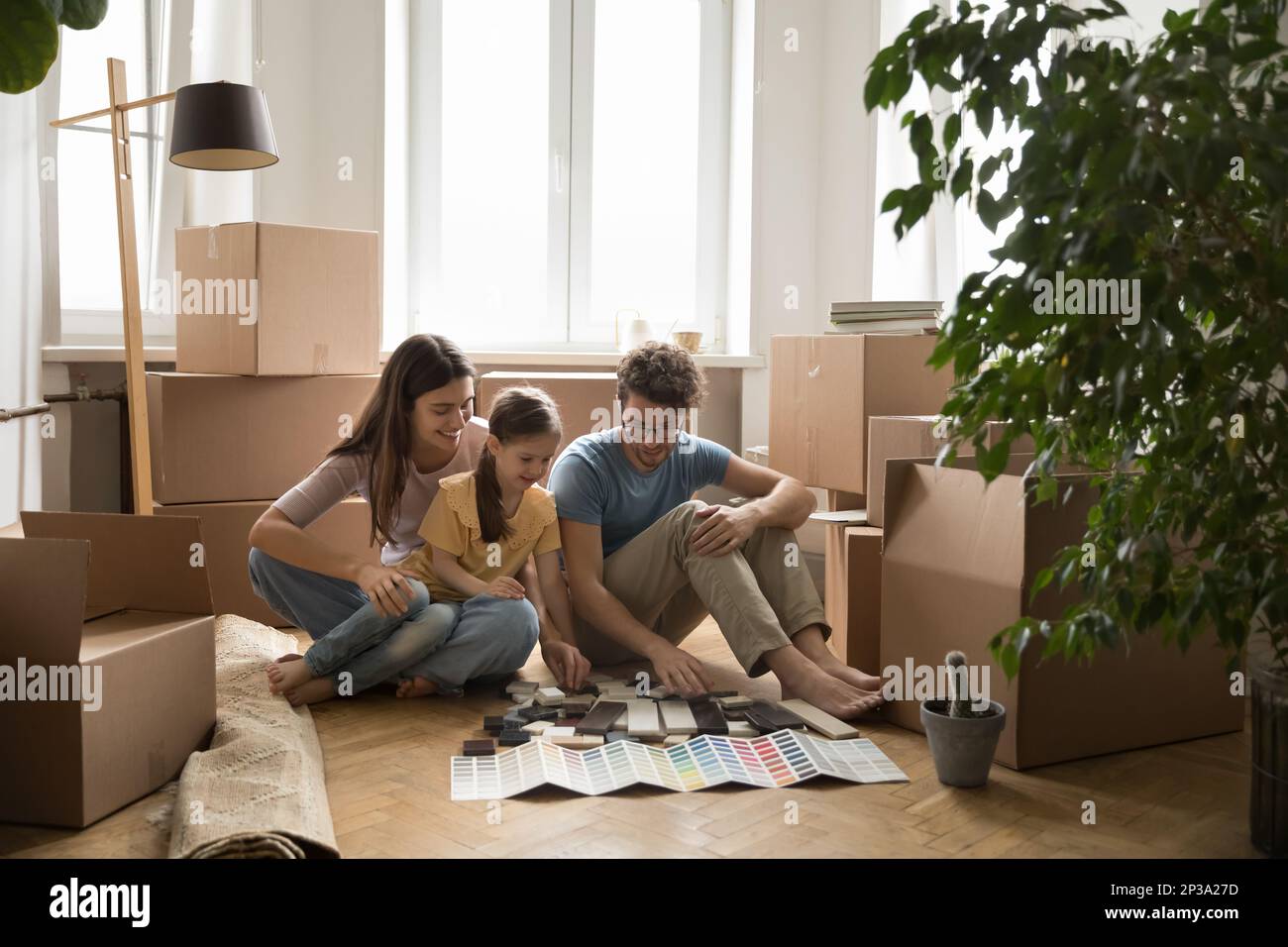 Happy engaged parents and little daughter girl choosing colors Stock ...