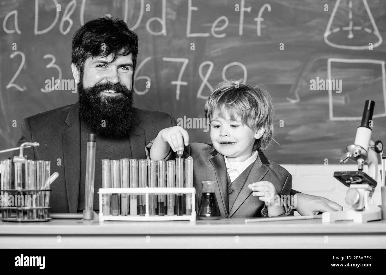 Laboratory test tubes and flasks with colored liquids. father and son ...