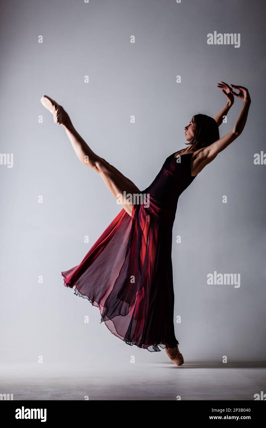 Half silhouette ballerina with a waving red dress. Elegant female ...