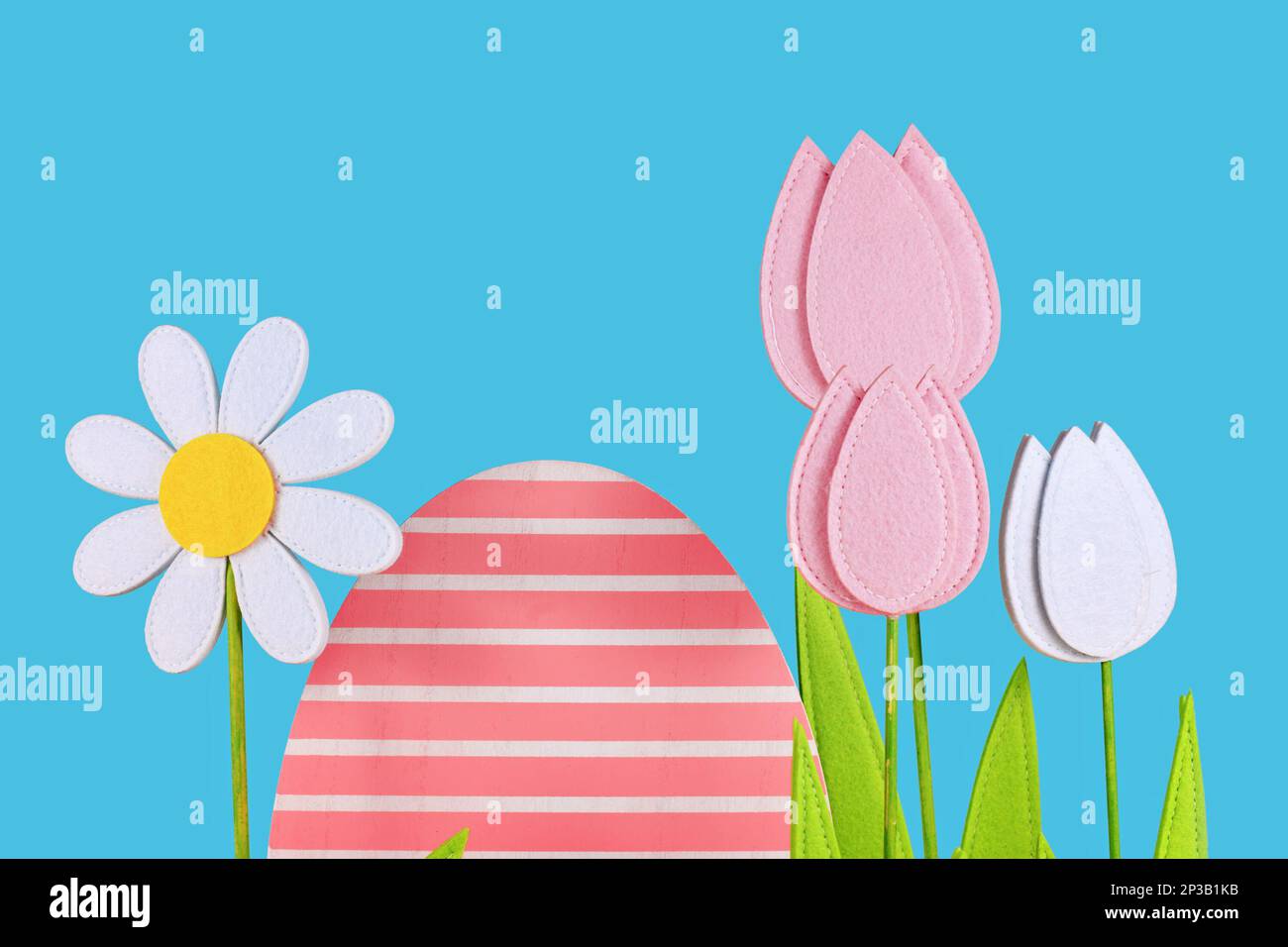Felt tulip and daisy spring flowers and easter egg on blue background ...