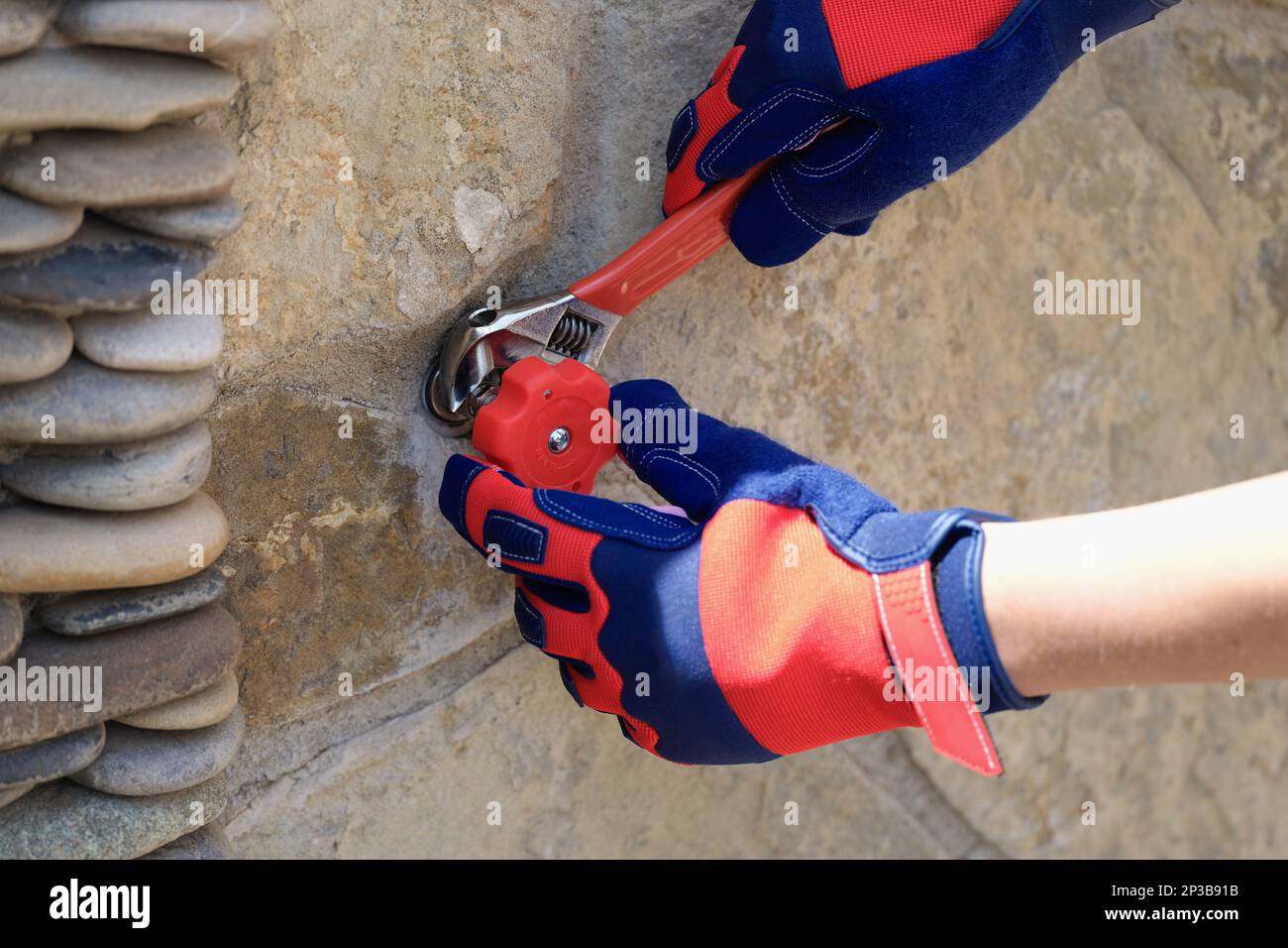 Craftsman installs water faucet on concrete wall close-up Stock Photo ...