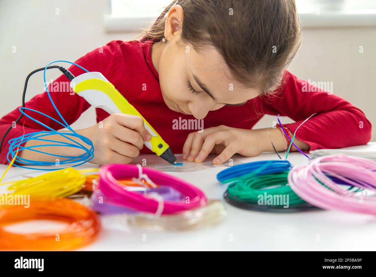 Child 3D drawings with a pen on the table. Selective focus. Kid Stock ...